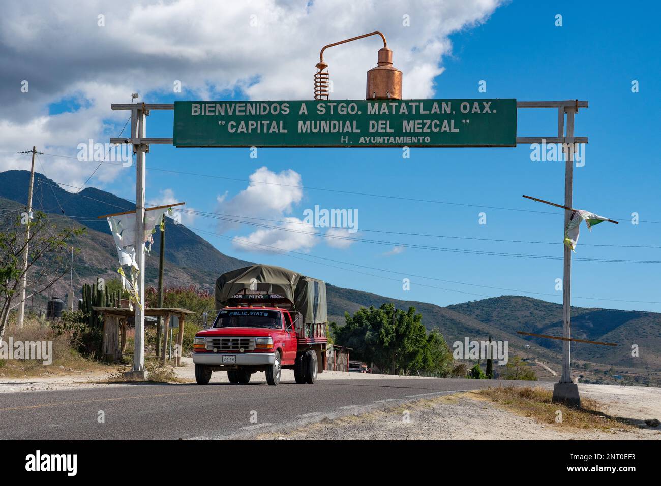 A copper mezcal still on top of the sign saying ""World Capital of ...