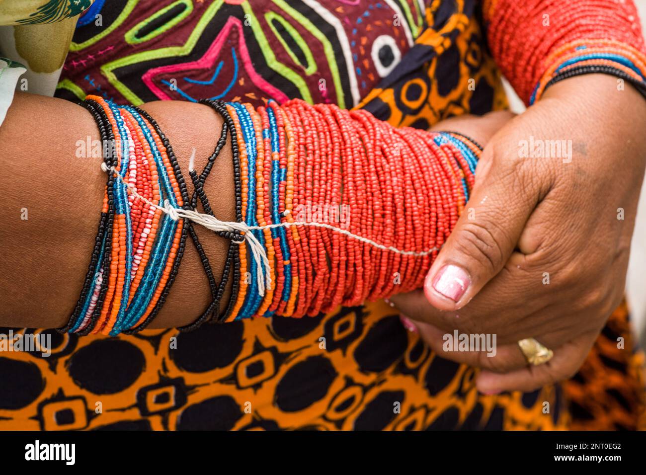 Long single strands of beads wrapped around the arms and legs of the ...