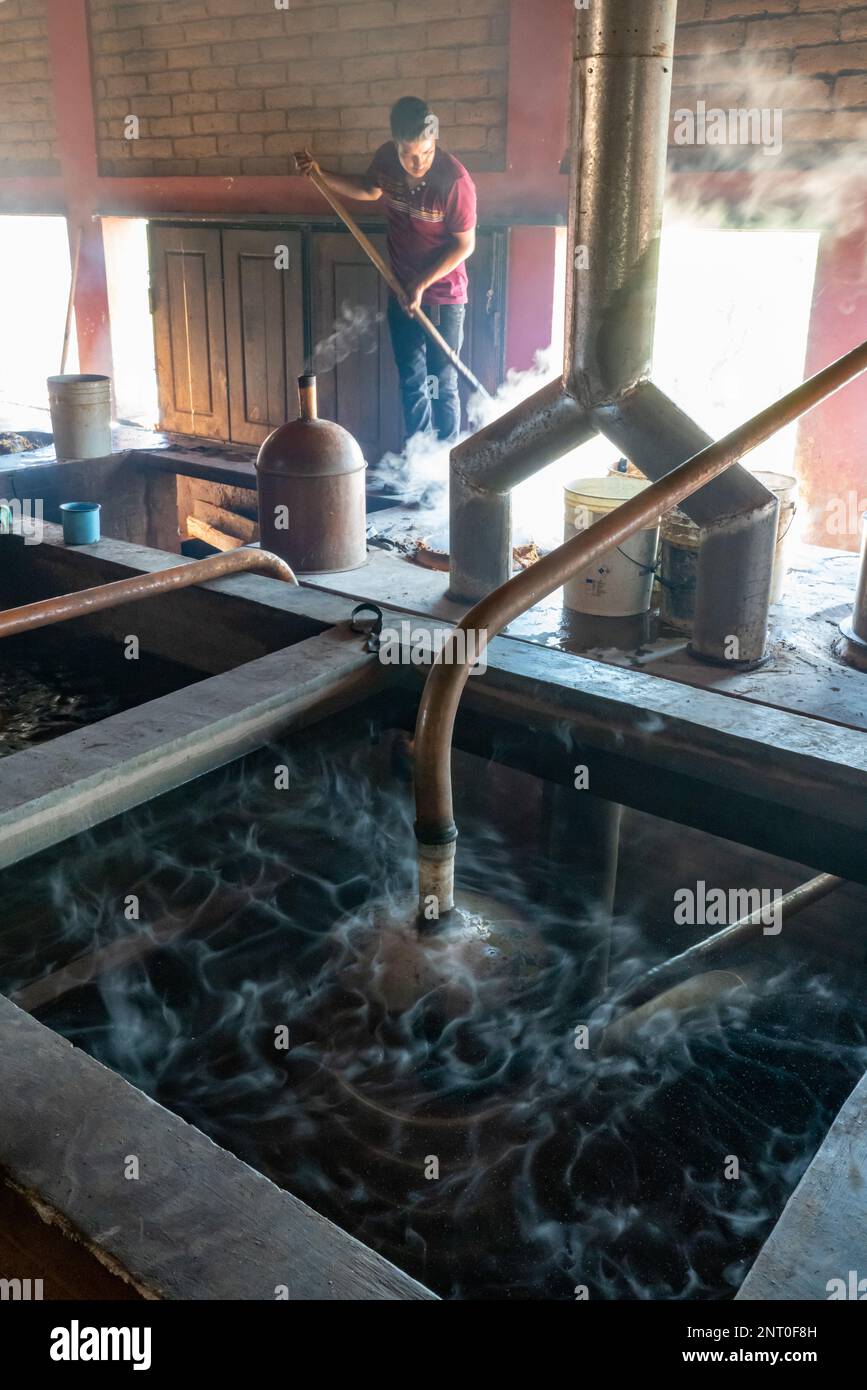 A worker tends a mezcal still at an artisanal mezcal distillery in ...