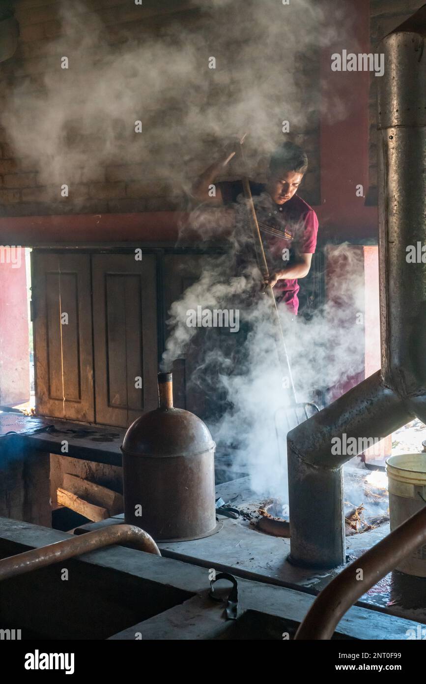 A worker tends a mezcal still at an artisanal mezcal distillery in ...