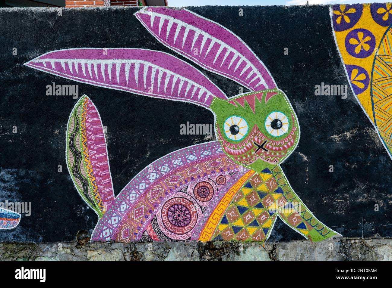 An alebrije rabbit painted on the side of house in San Antonio Arrazola ...