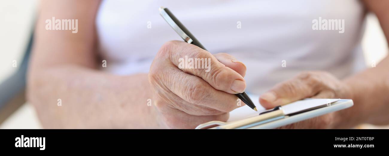 Hands of old woman with sheet for writing text Stock Photo - Alamy
