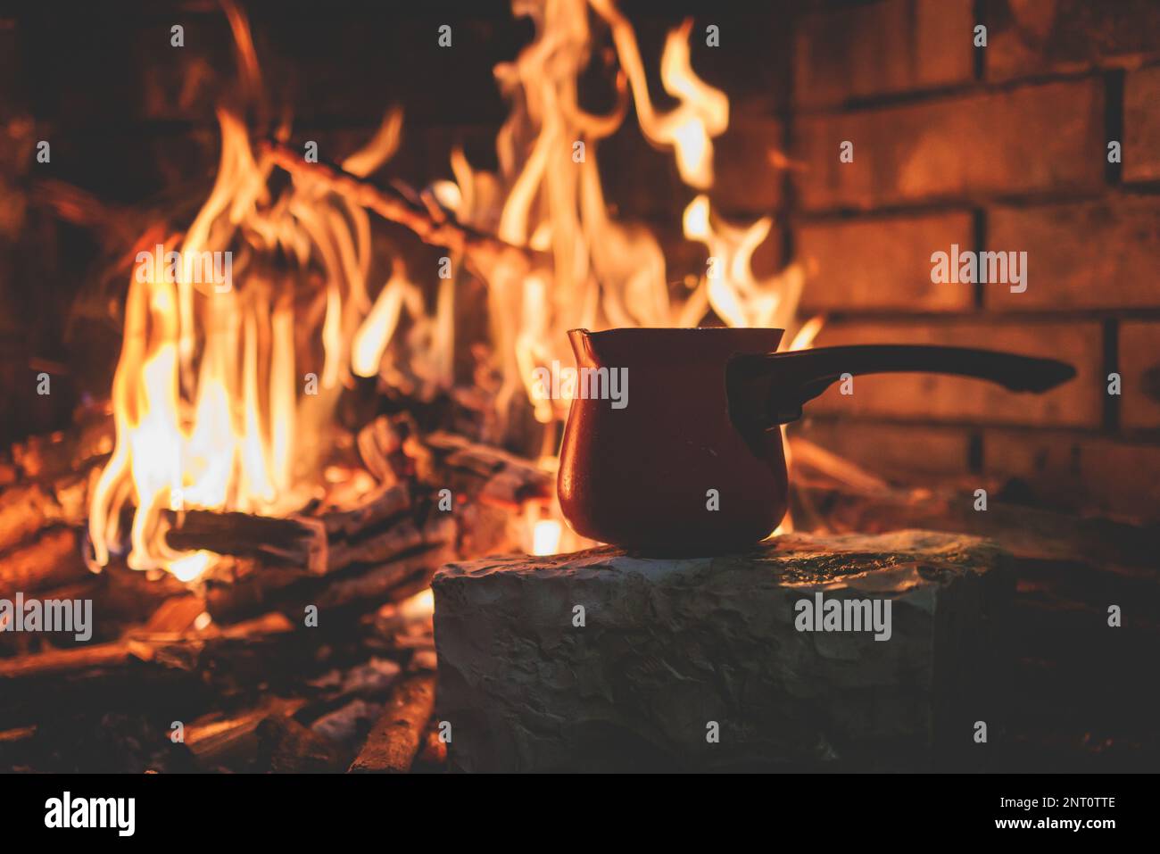 Warming up the fire, cozy winter night in the scandinavian cottage ...