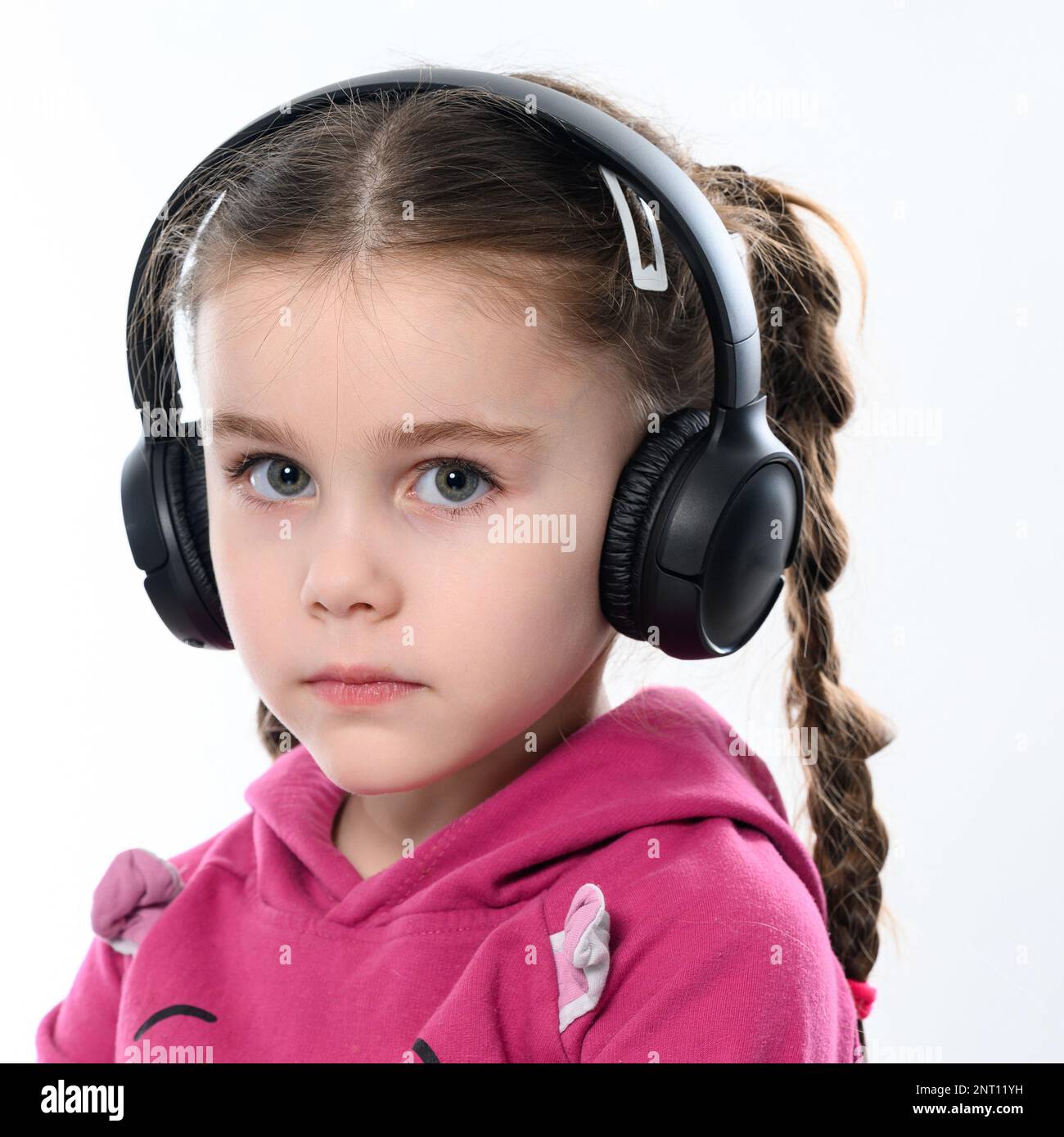 A girl on a white background with headphones on her head, portrait of a ...