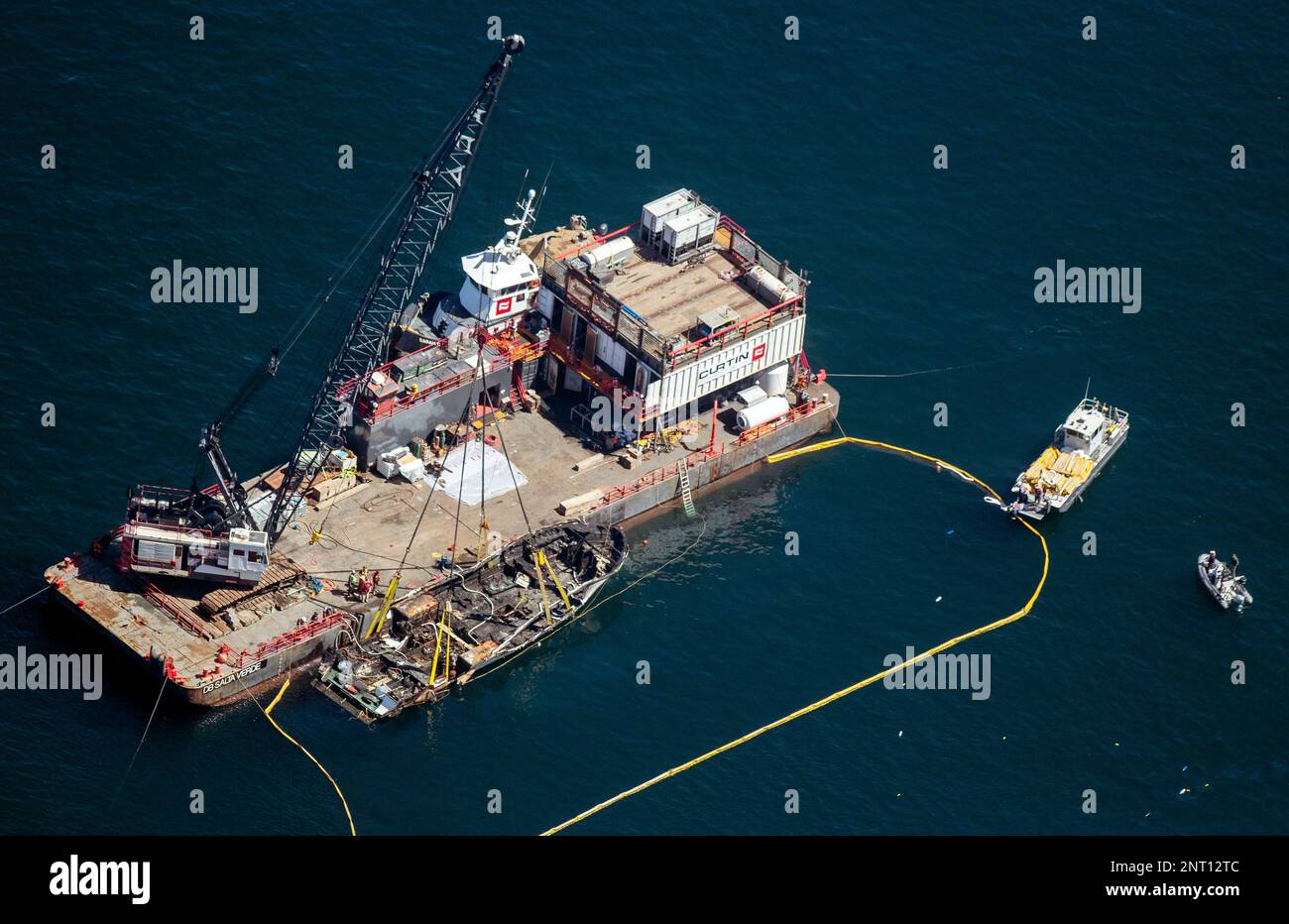 The burned hull of the Conception is brought to the surface by a ...