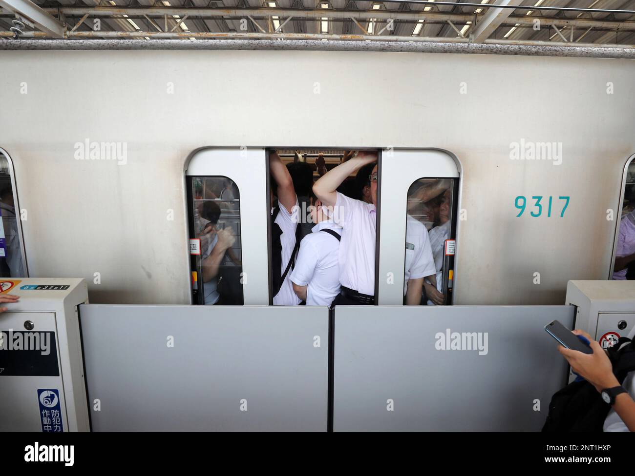 Workers ride a packed train during rush hour in Tokyo on Sep.9, 2019 ...