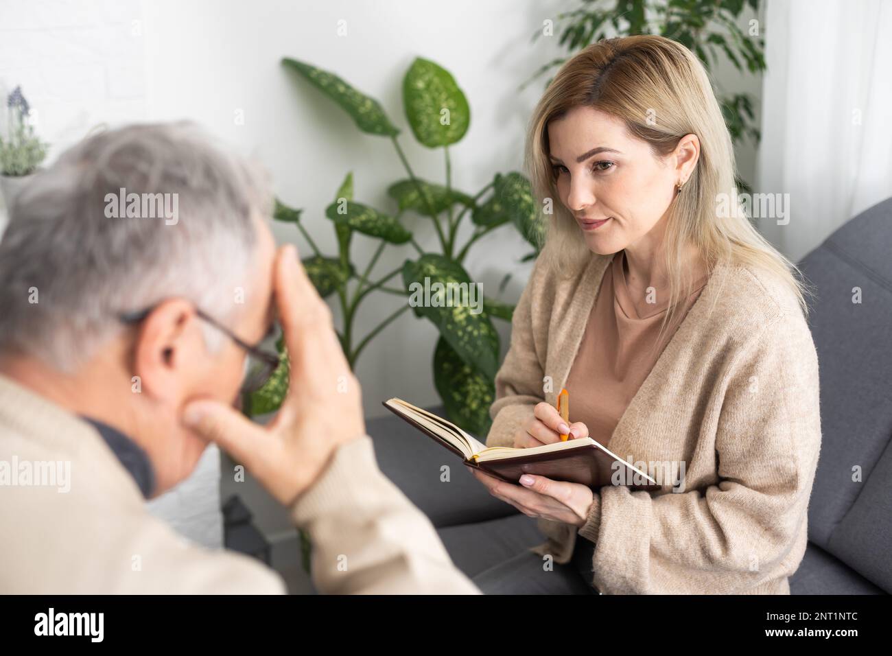 Mature man at a session with a psychologist. The doctor listens and ...
