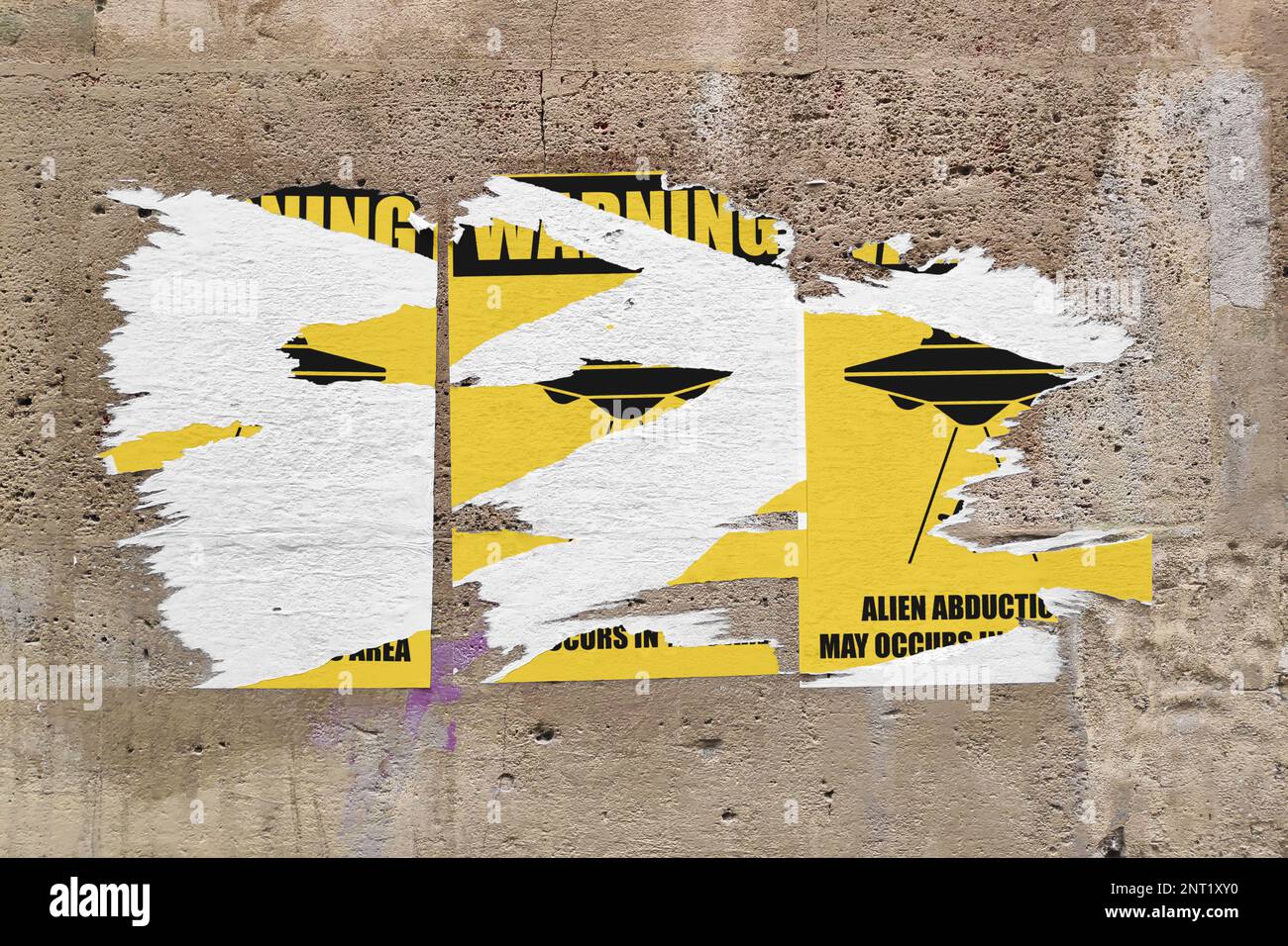 Full-frame weathered limestone wall with three torn yellow and black ...