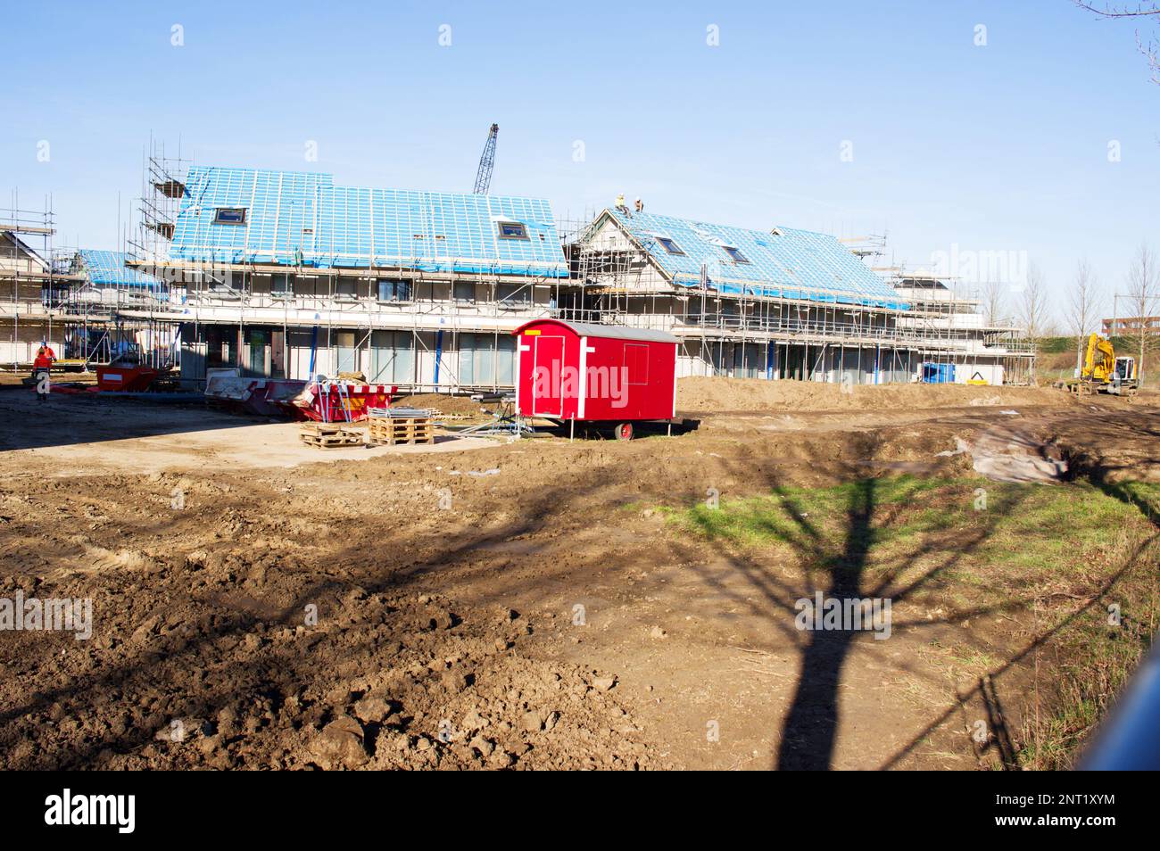 Terraced houses under construction with two construction workers on the ...