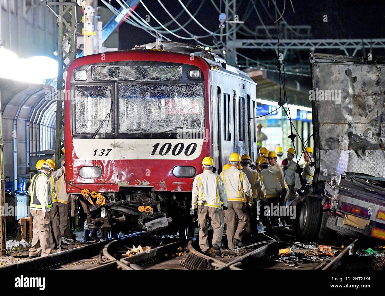 Workers push a train of KeikyuLine between Kanagawa Shinmachi Station ...