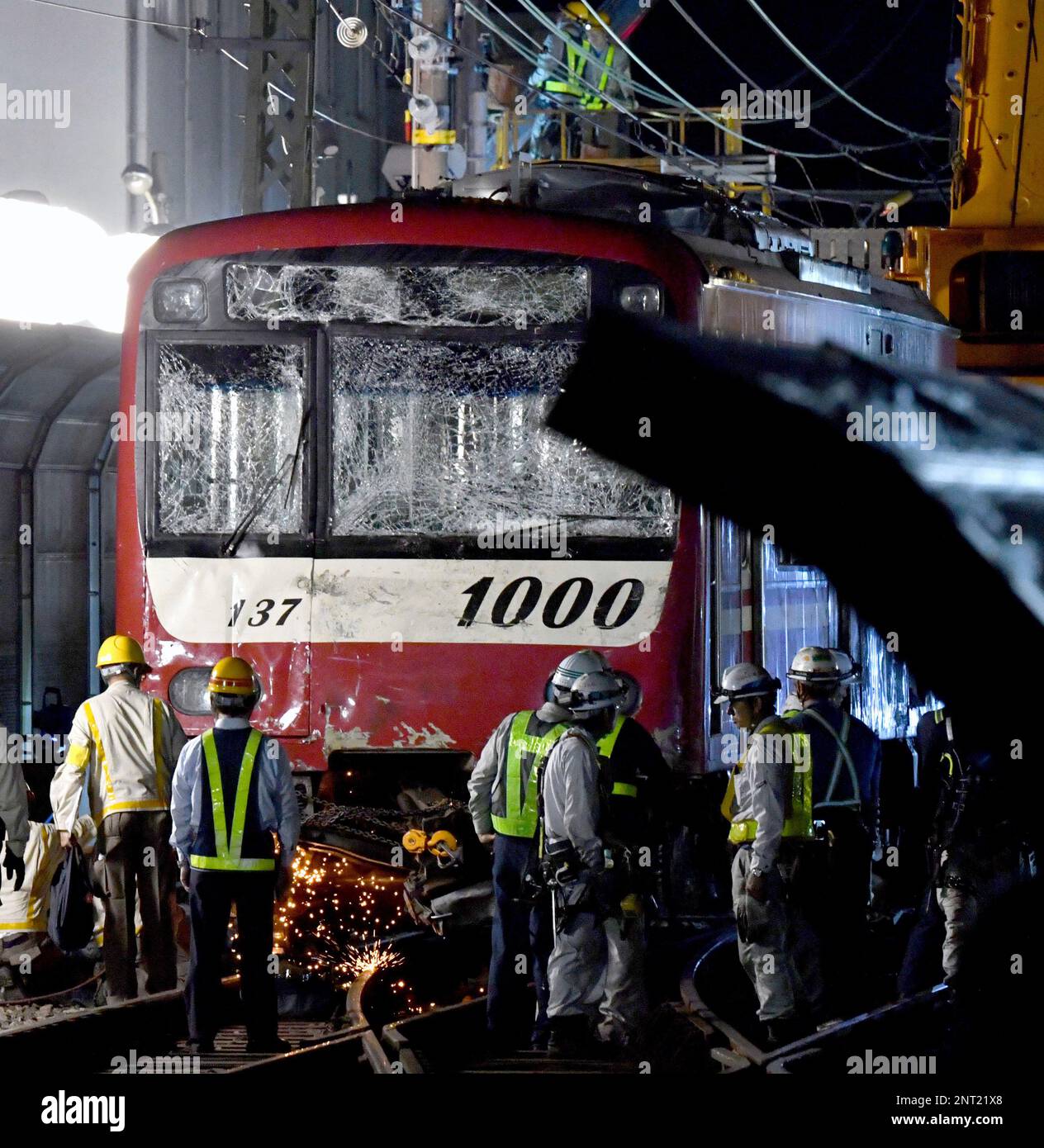 Workers push a train of KeikyuLine between Kanagawa Shinmachi Station ...