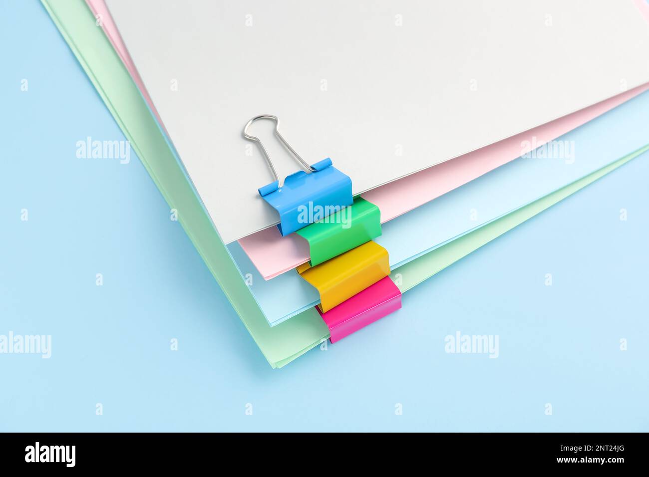 Paper sheets with binder clips on color background, closeup Stock Photo ...