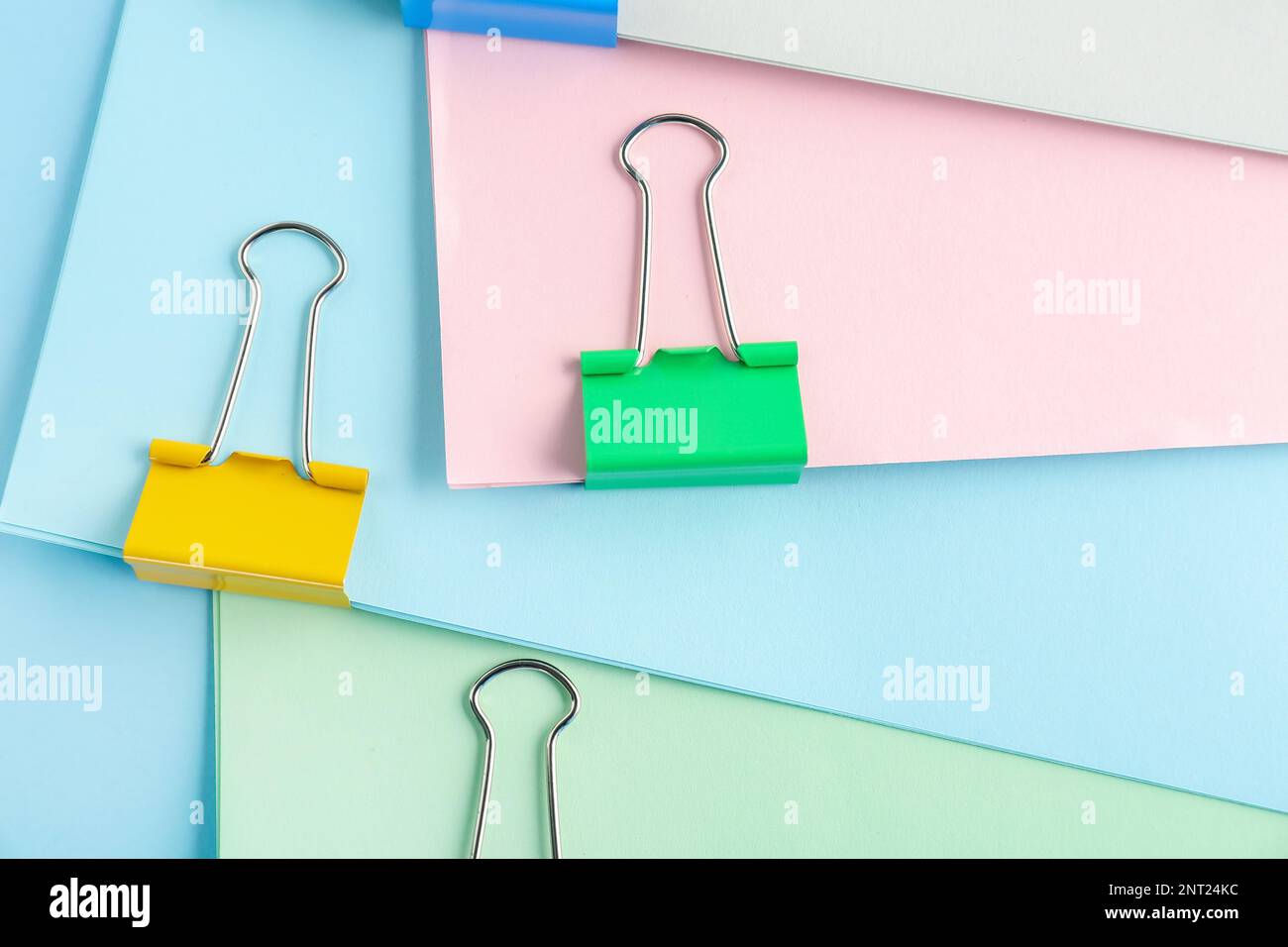 Paper sheets with binder clips on color background, closeup Stock Photo ...