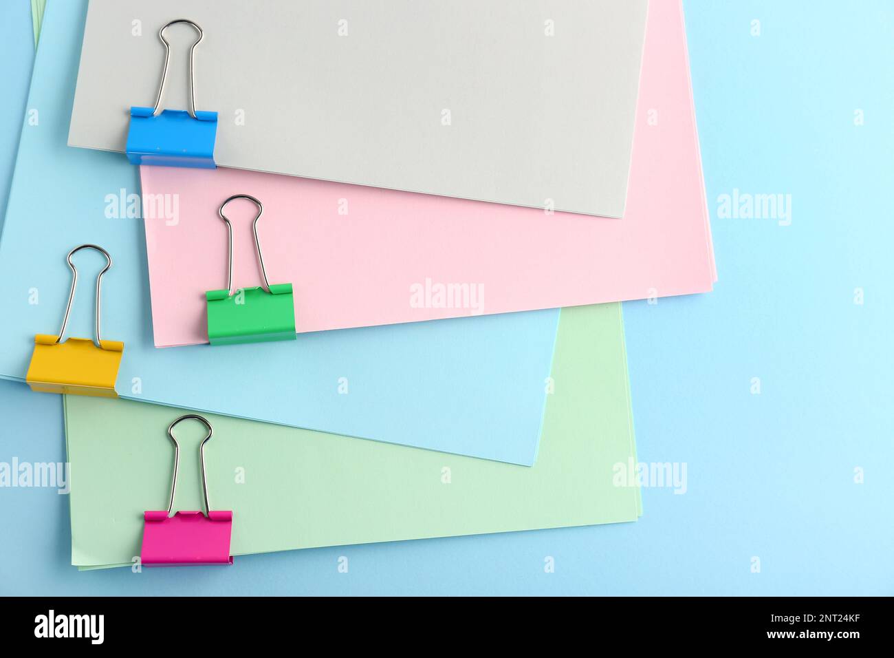 Paper sheets with binder clips on color background, closeup Stock Photo ...