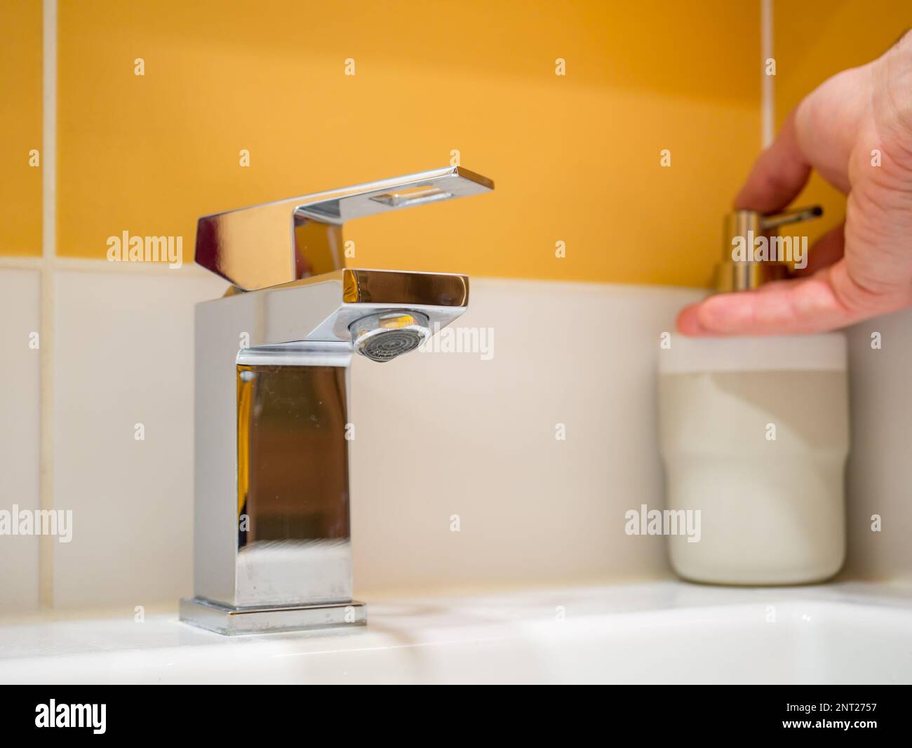 Using a soap dispenser for a basin with a square faucet Stock Photo - Alamy