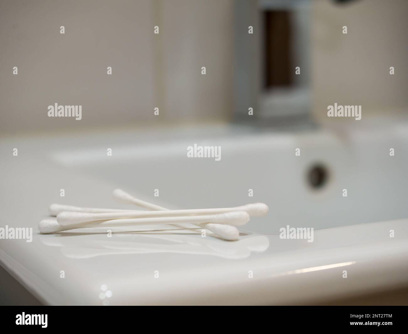 Cotton swabs in the ears on a white background Stock Photo - Alamy