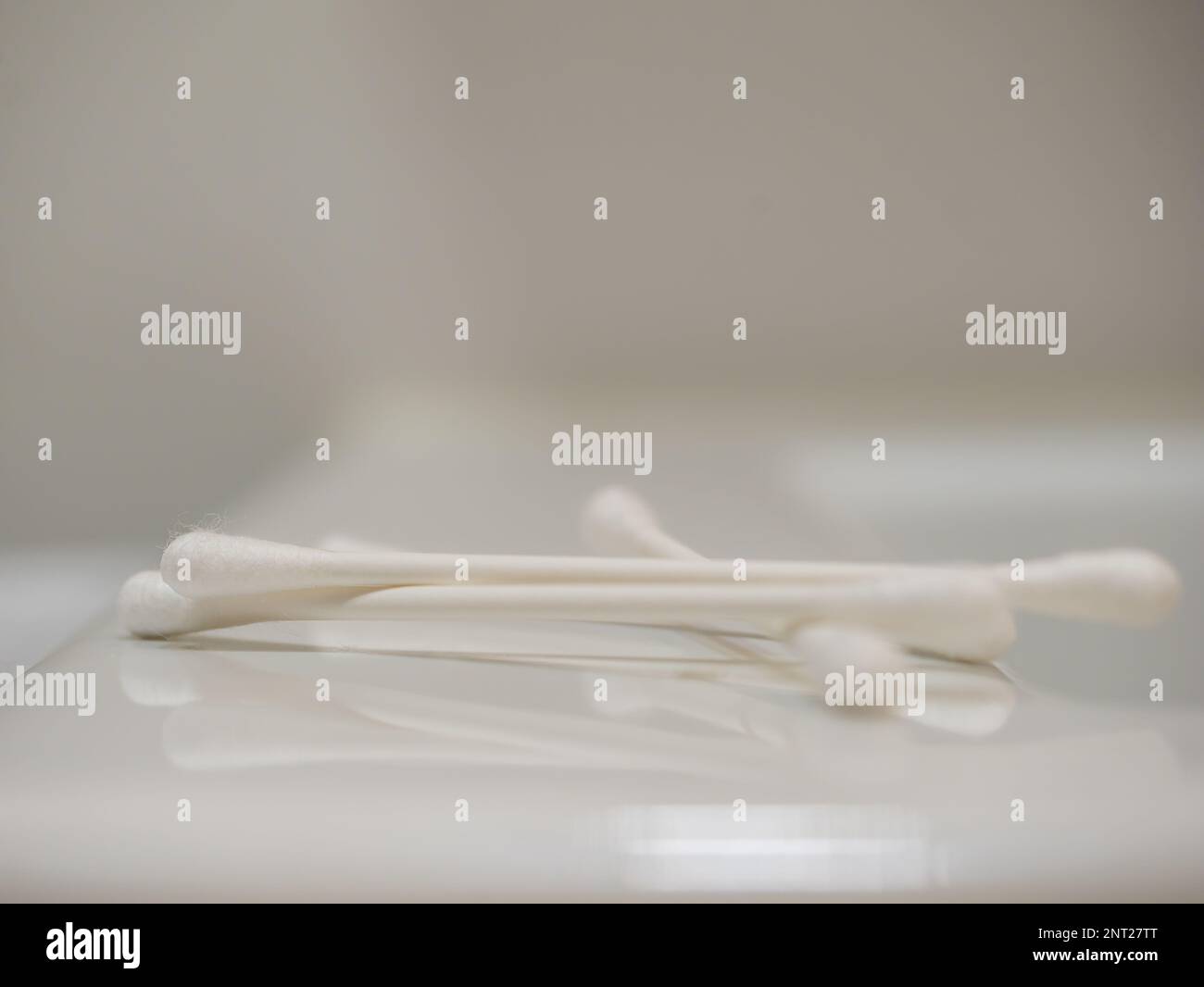 Cotton swabs in the ears on a white background Stock Photo - Alamy
