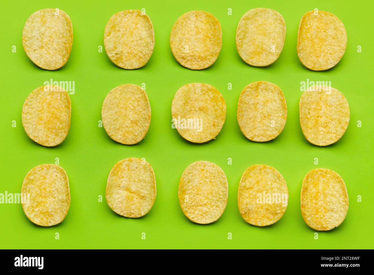 Many delicious potato chips on green background Stock Photo - Alamy