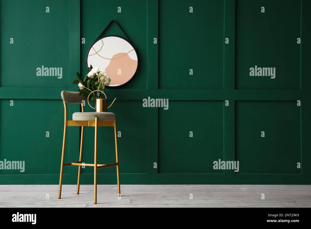 Vase with ranunculus flowers on stool near green wall in room Stock ...
