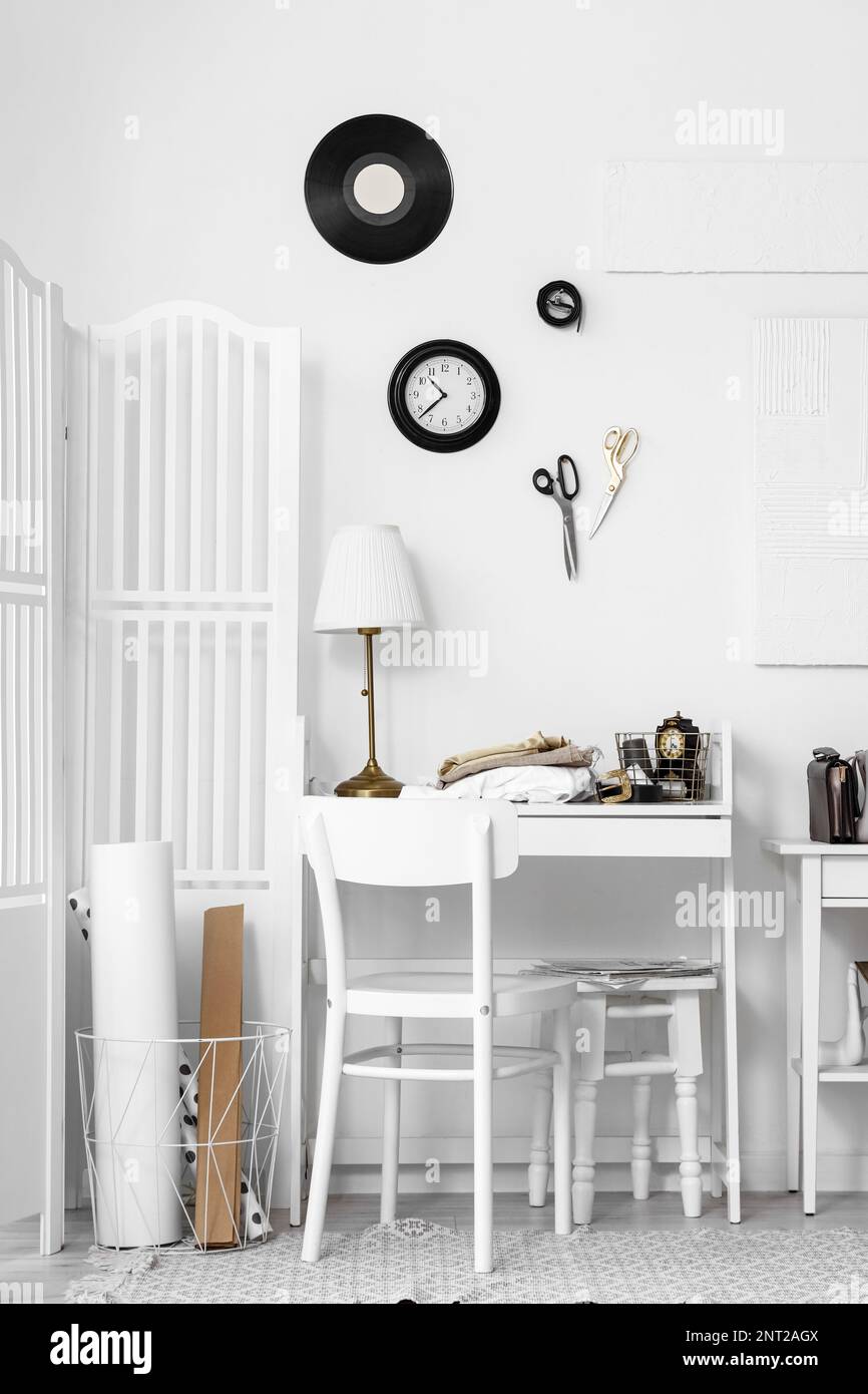 Interior of modern atelier with tailor's workplace and folding screen ...