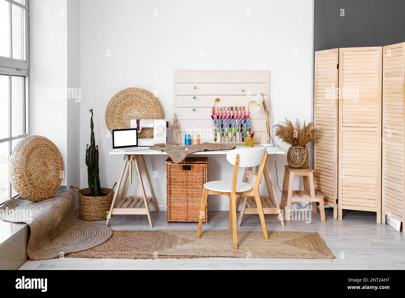 Interior of modern atelier with tailor's workplace, poufs and folding ...