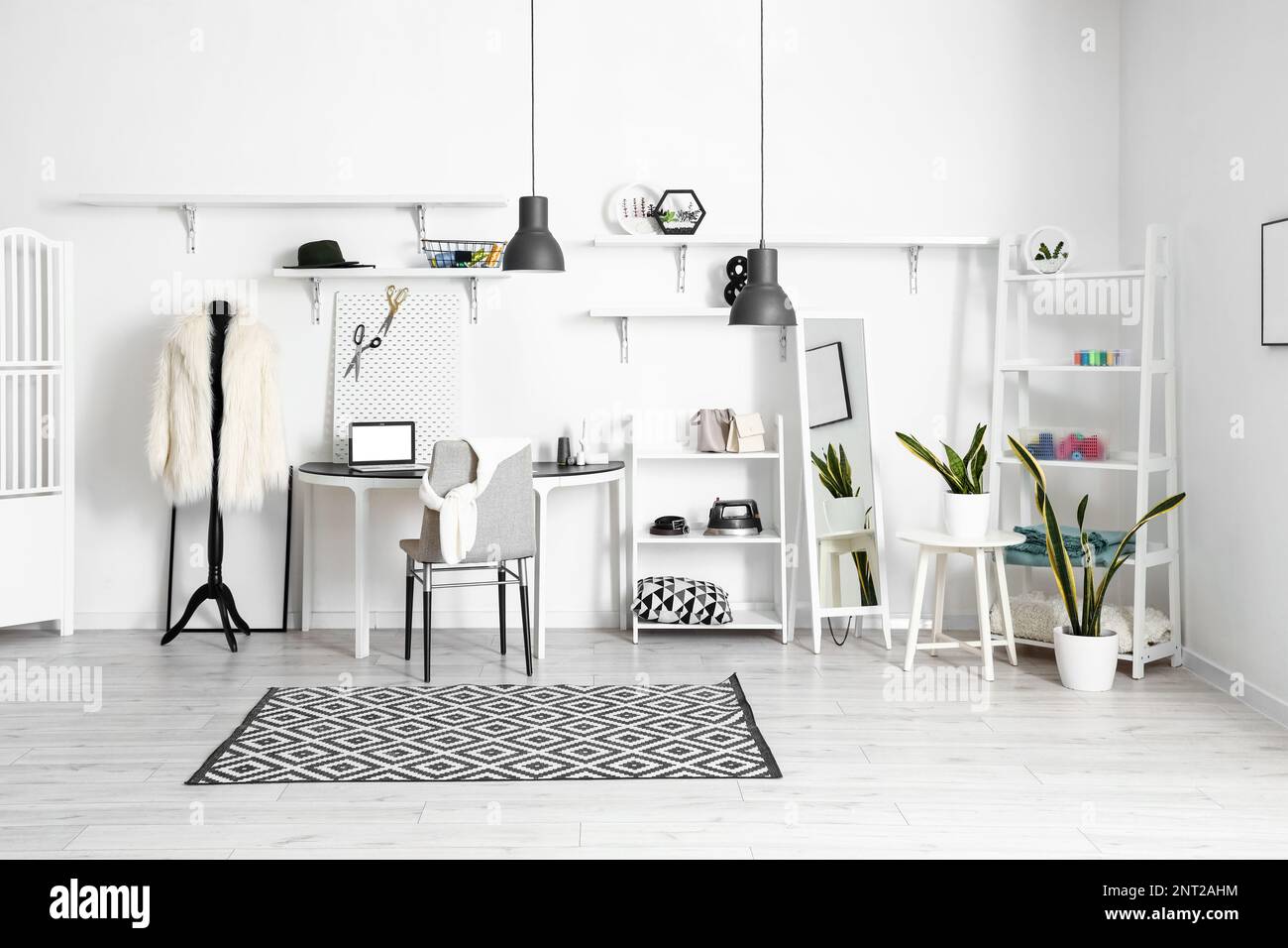 Interior of modern atelier with tailor's workplace, shelving units and ...