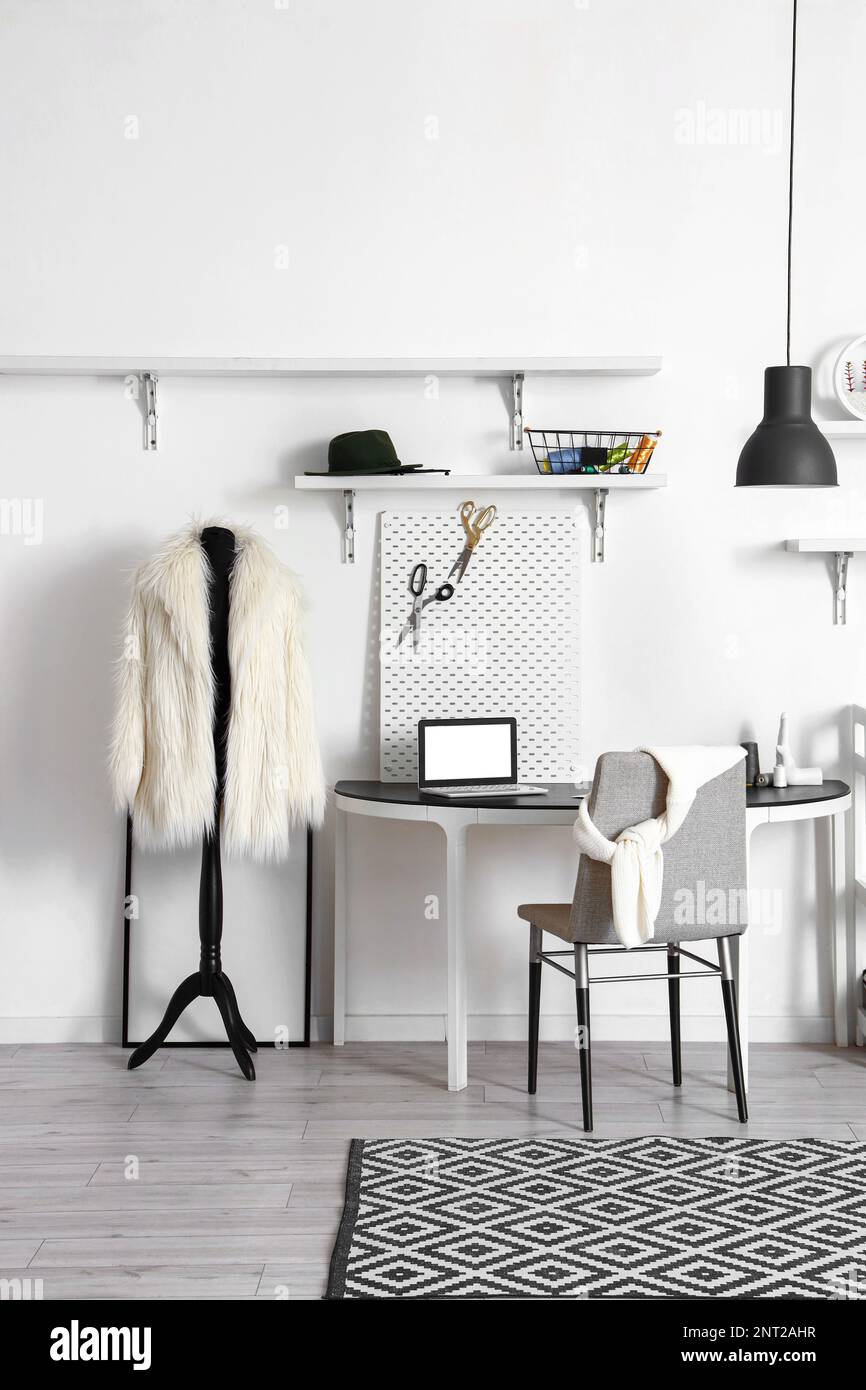 Interior of modern atelier with tailor's workplace, shelves and ...