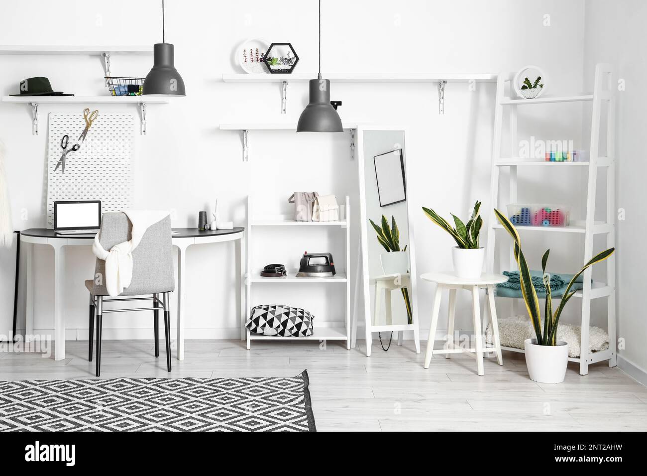 Interior of modern atelier with tailor's workplace, shelving units and ...