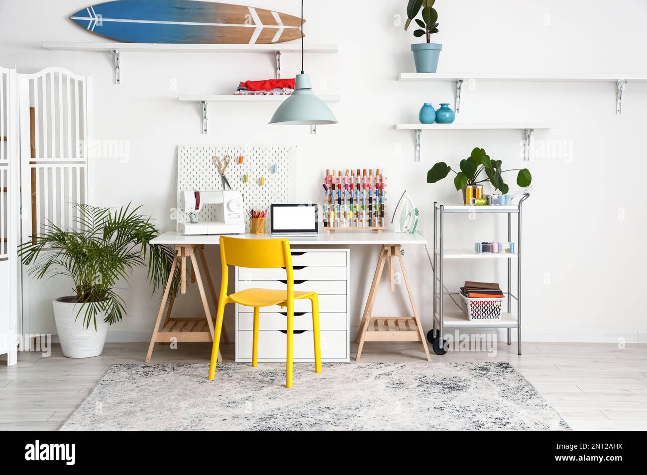 Interior of modern atelier with tailor's workplace, shelves and ...