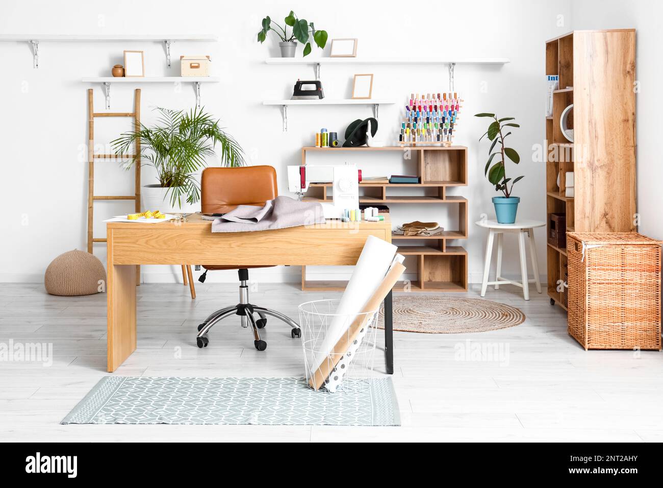 Interior of modern atelier with tailor's workplace and shelving units ...