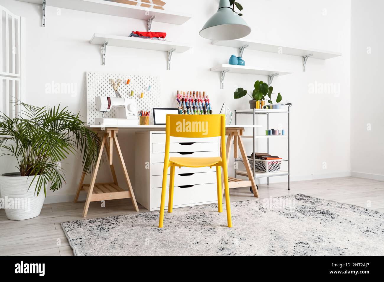 Interior of modern atelier with tailor's workplace and shelves Stock ...