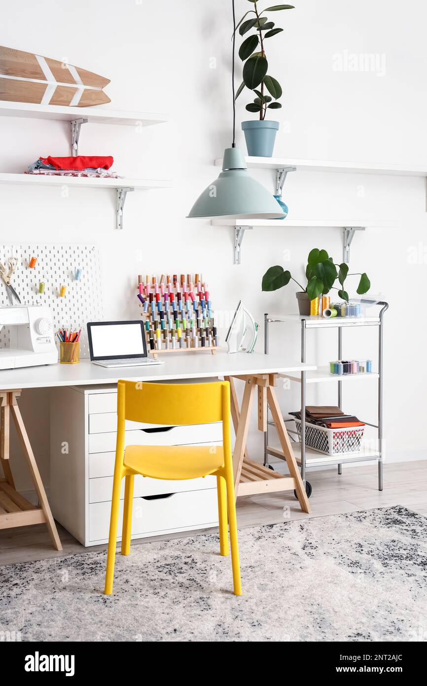 Interior of modern atelier with tailor's workplace and shelves Stock ...
