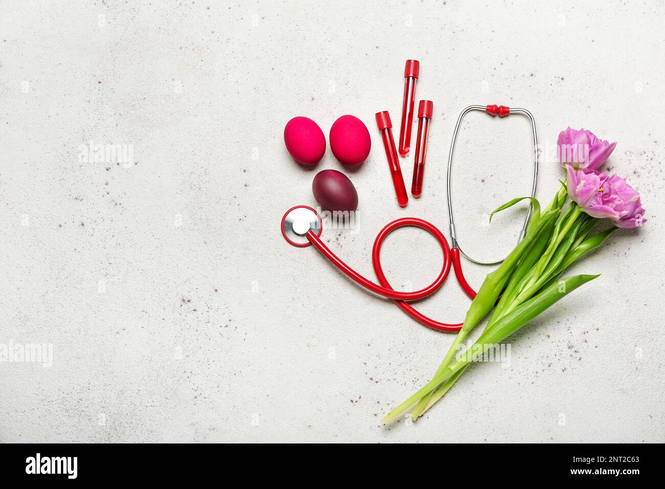 Stethoscope with test tubes, Easter eggs and flowers on light ...