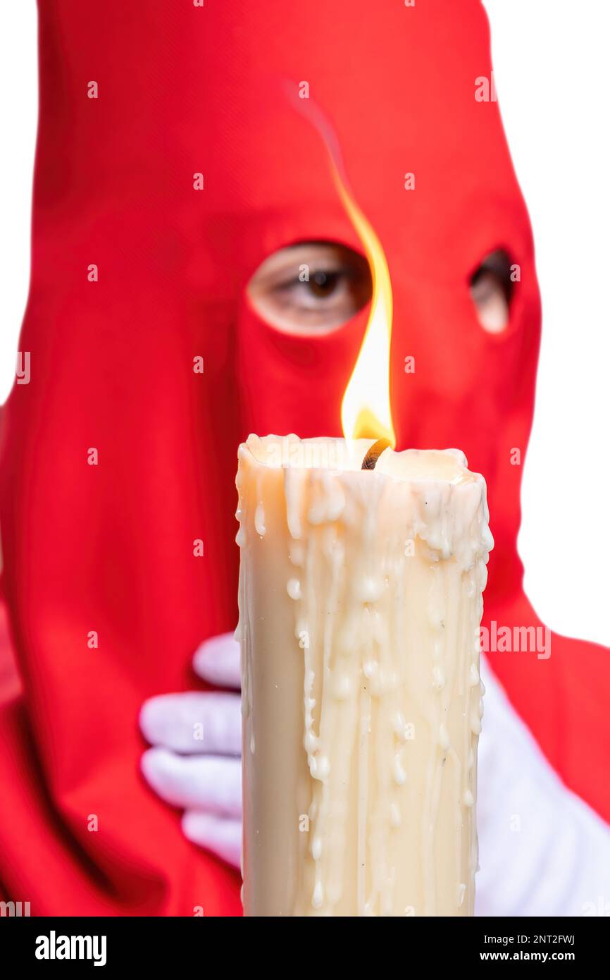 The candle in flame of a young Nazarene with a red hood doing his ...