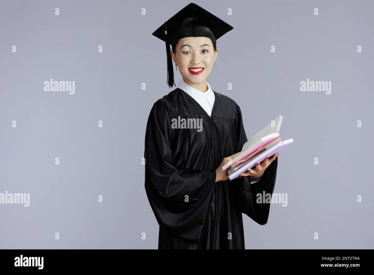 happy young graduate student asian woman with books and notebooks ...