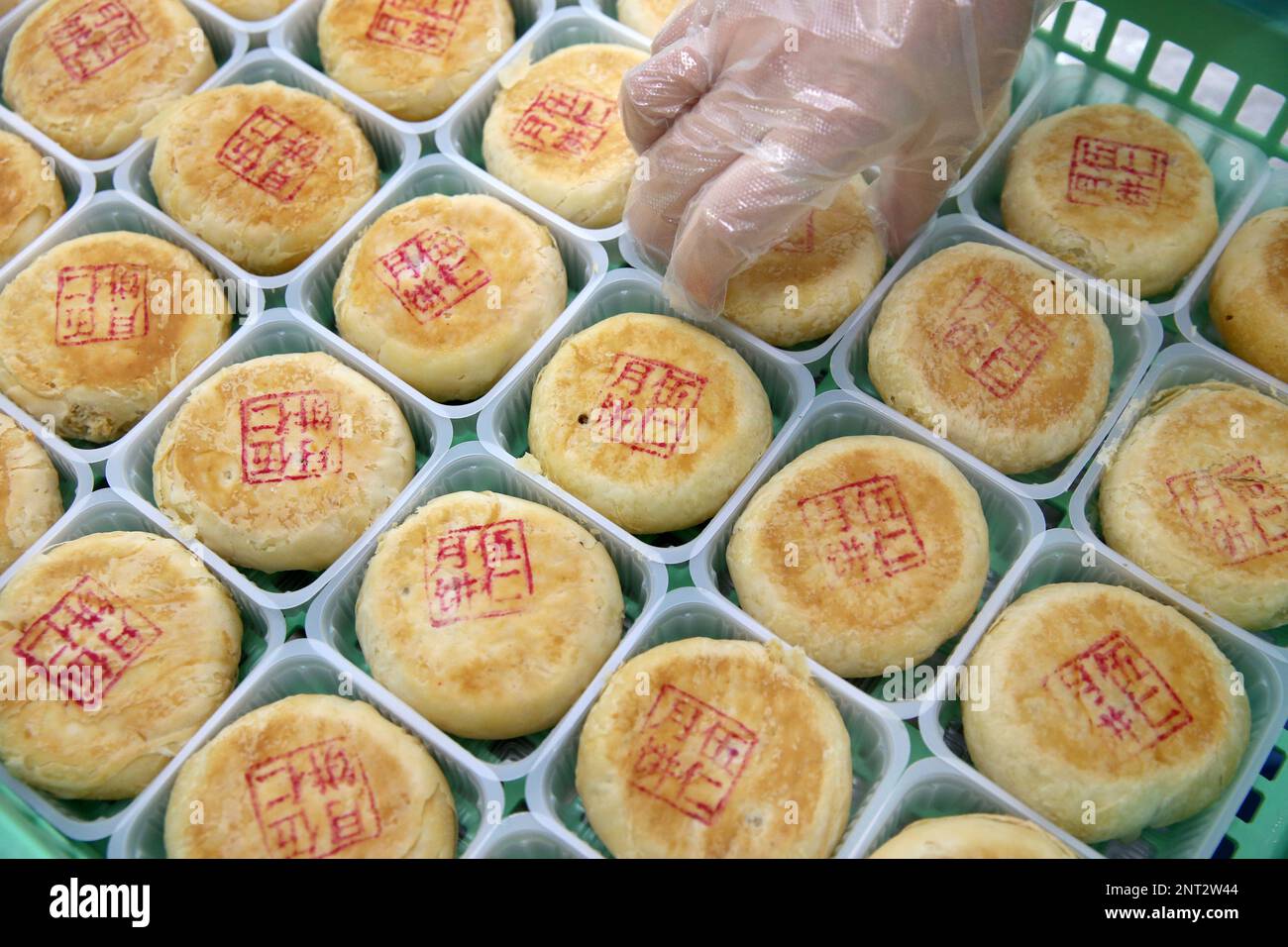 A worker makes mooncakes for the upcoming Moon Festival in a food ...