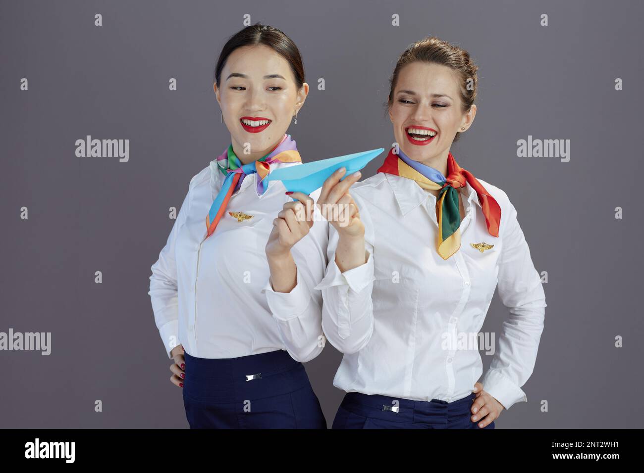 smiling elegant air hostess women in blue skirt, white shirt and scarf ...
