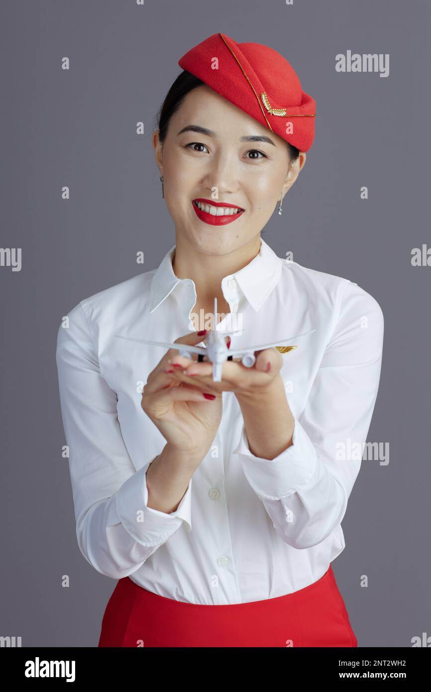 happy elegant asian female stewardess in red skirt and hat uniform with ...