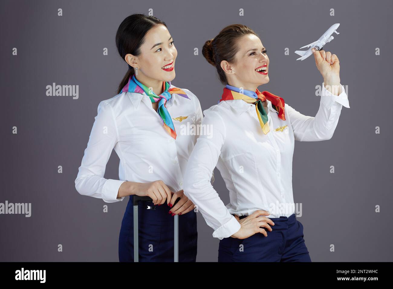 happy modern female flight attendants in blue skirt, white shirt and ...