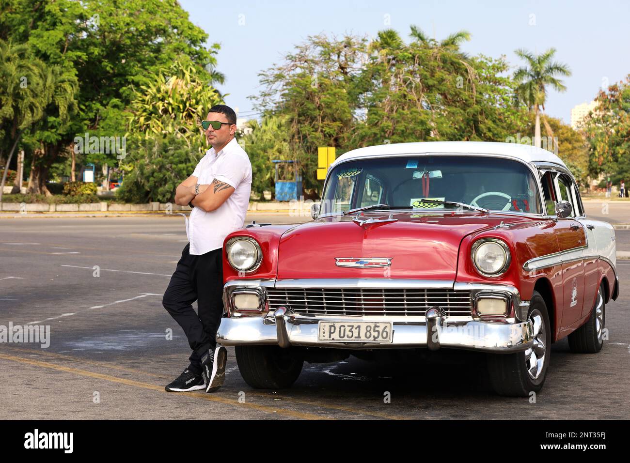 Taxi driver waiting tourists near vintage classic car Chevrolet on city ...
