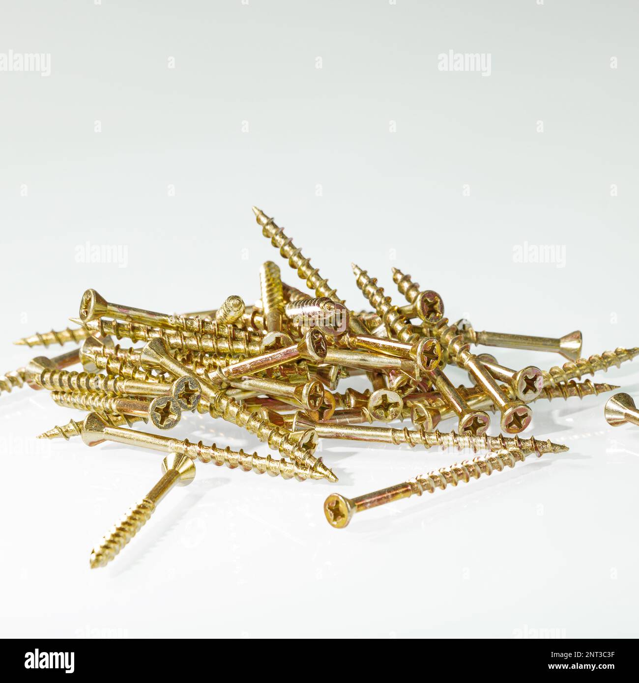 A group of yellow construction screws for connecting wooden parts.On a ...