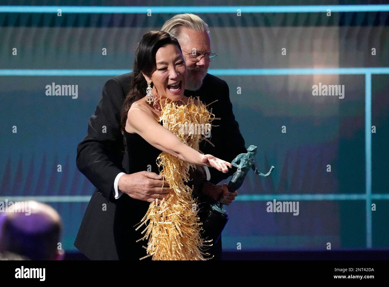 Jeff Bridges, left, presents Michelle Yeoh with the award for ...