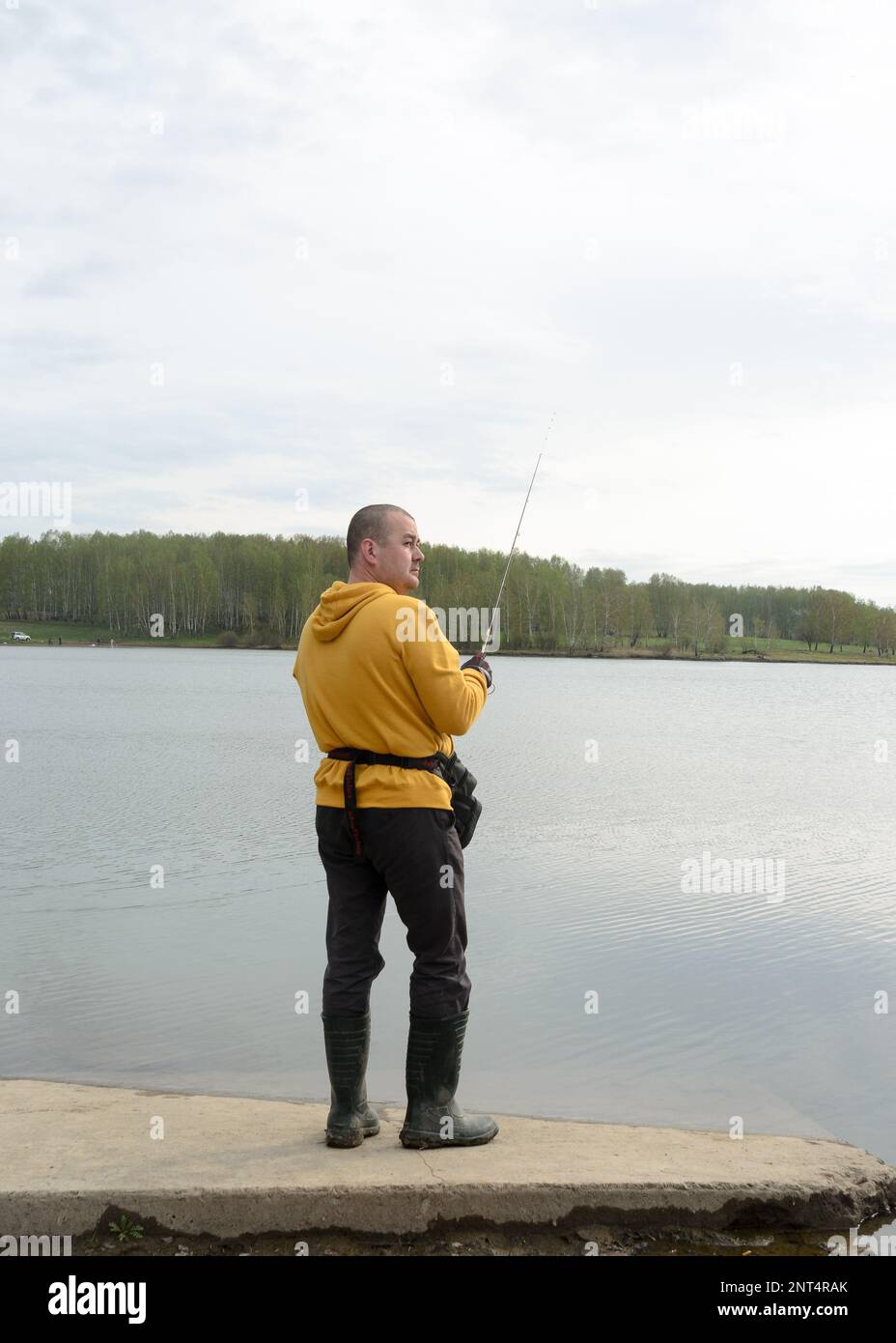 Russian modern male fisherman fishes on an ultralight spinning rod in ...