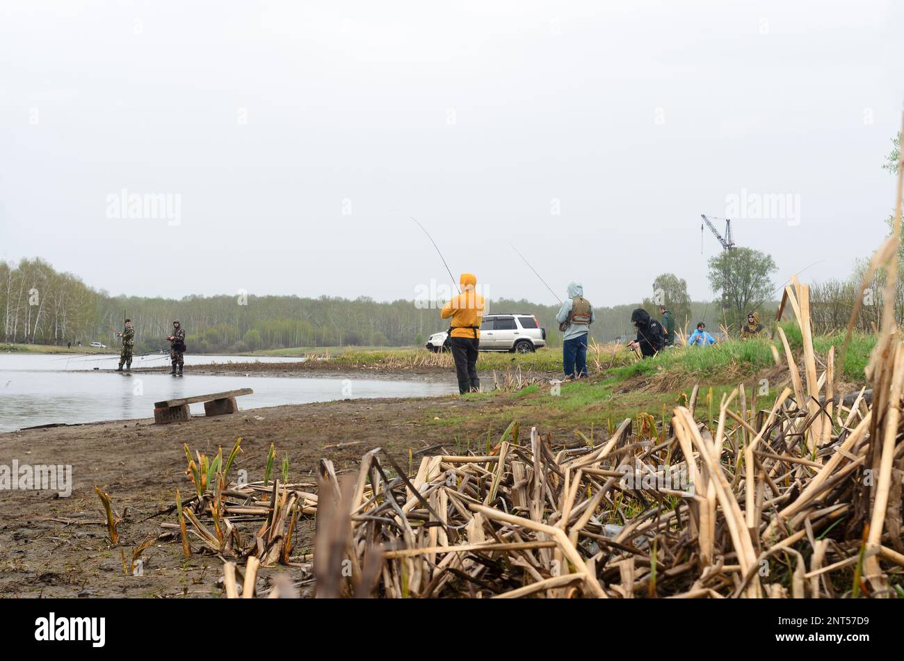 A lot of Russian modern male fishermen are fishing on the shore of the ...