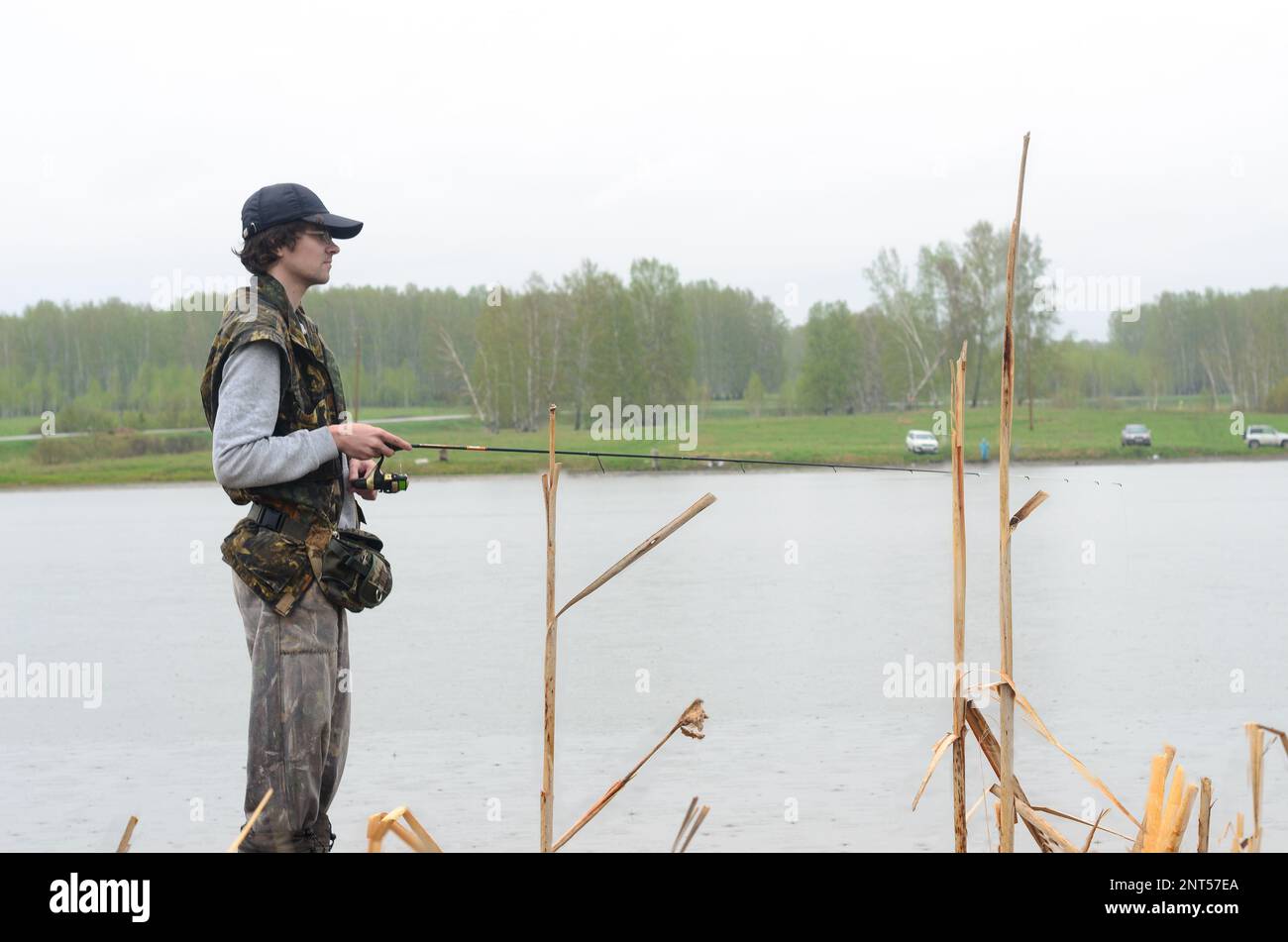 Russian modern male fisherman fishes on an ultralight spinning rod in ...