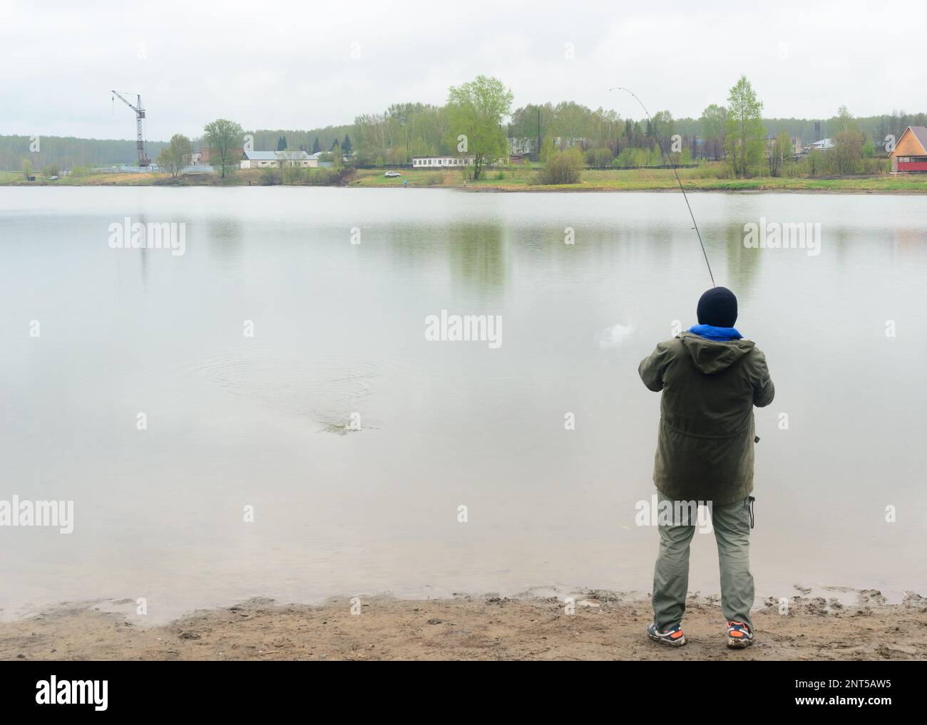 Russian modern male fisherman fishes on an ultralight spinning rod in ...