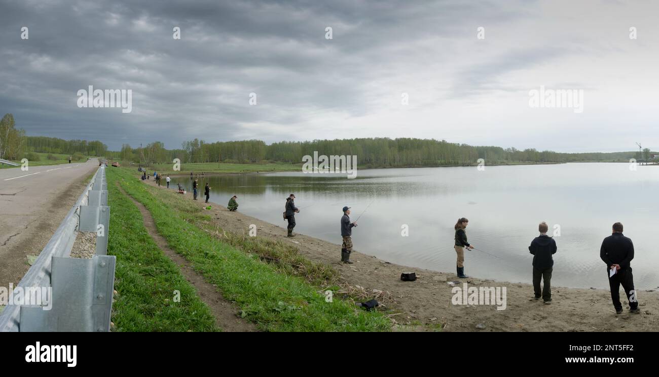 A lot of Russian modern male fishermen are fishing on the shore of the ...