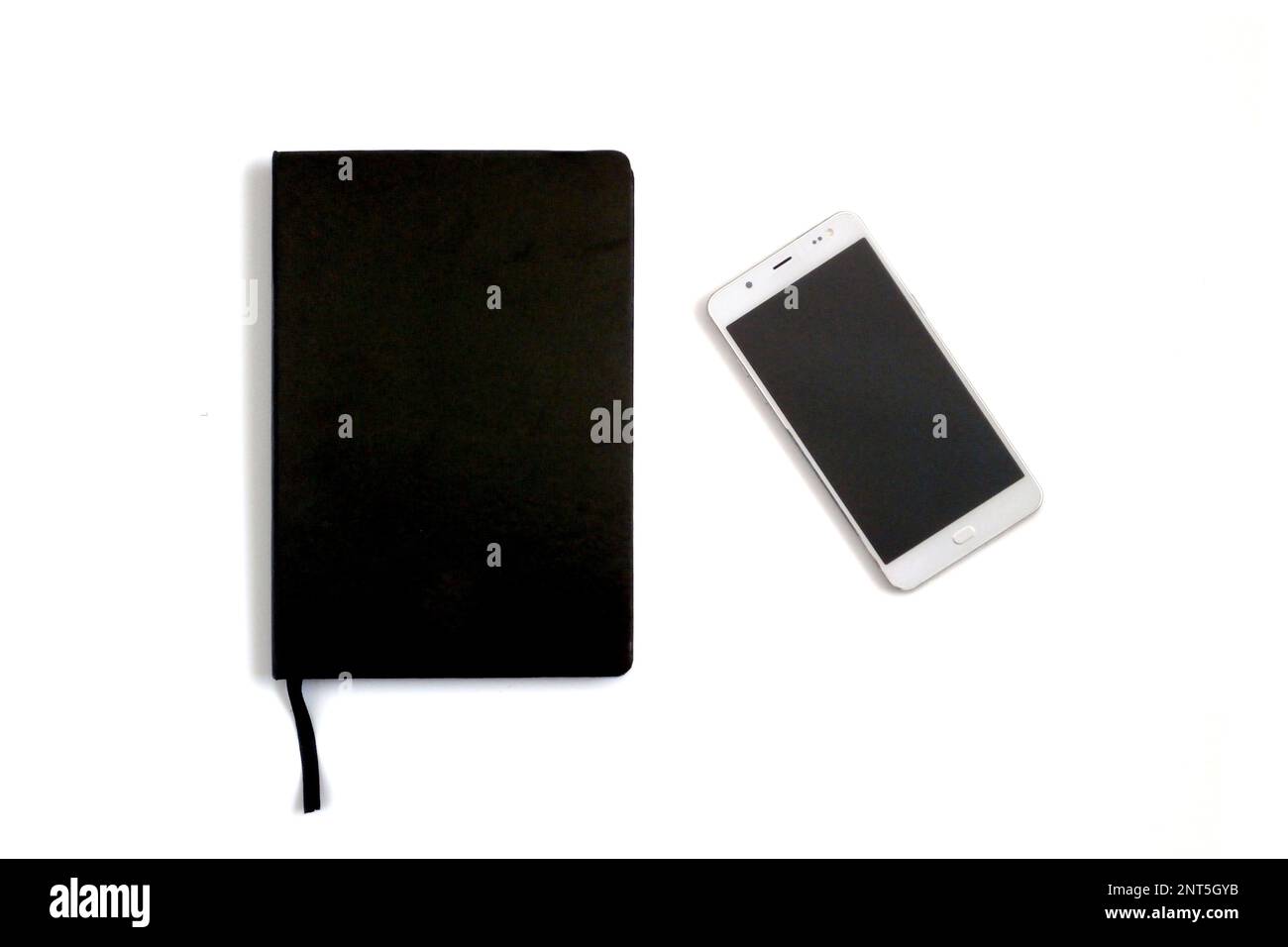 A black leather notebook by the side of a white unmarked smartphone on ...