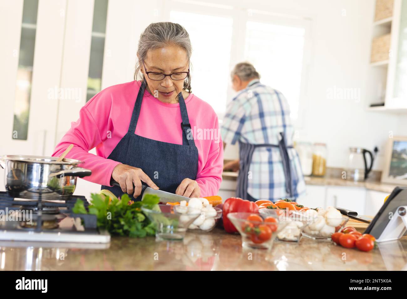 Happy senior diverse couple cooking dinner in kitchen Stock Photo - Alamy