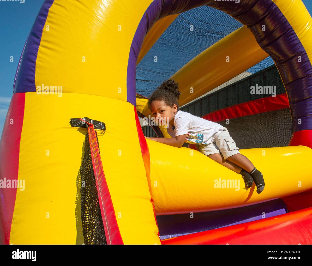 Three-year-old Jeremiah Lewis climbs through one of the inflatables ...